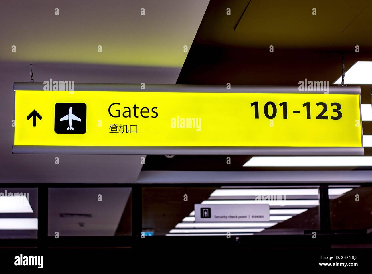 Bright illuminated yellow and black airport signs with arrows and plane ...