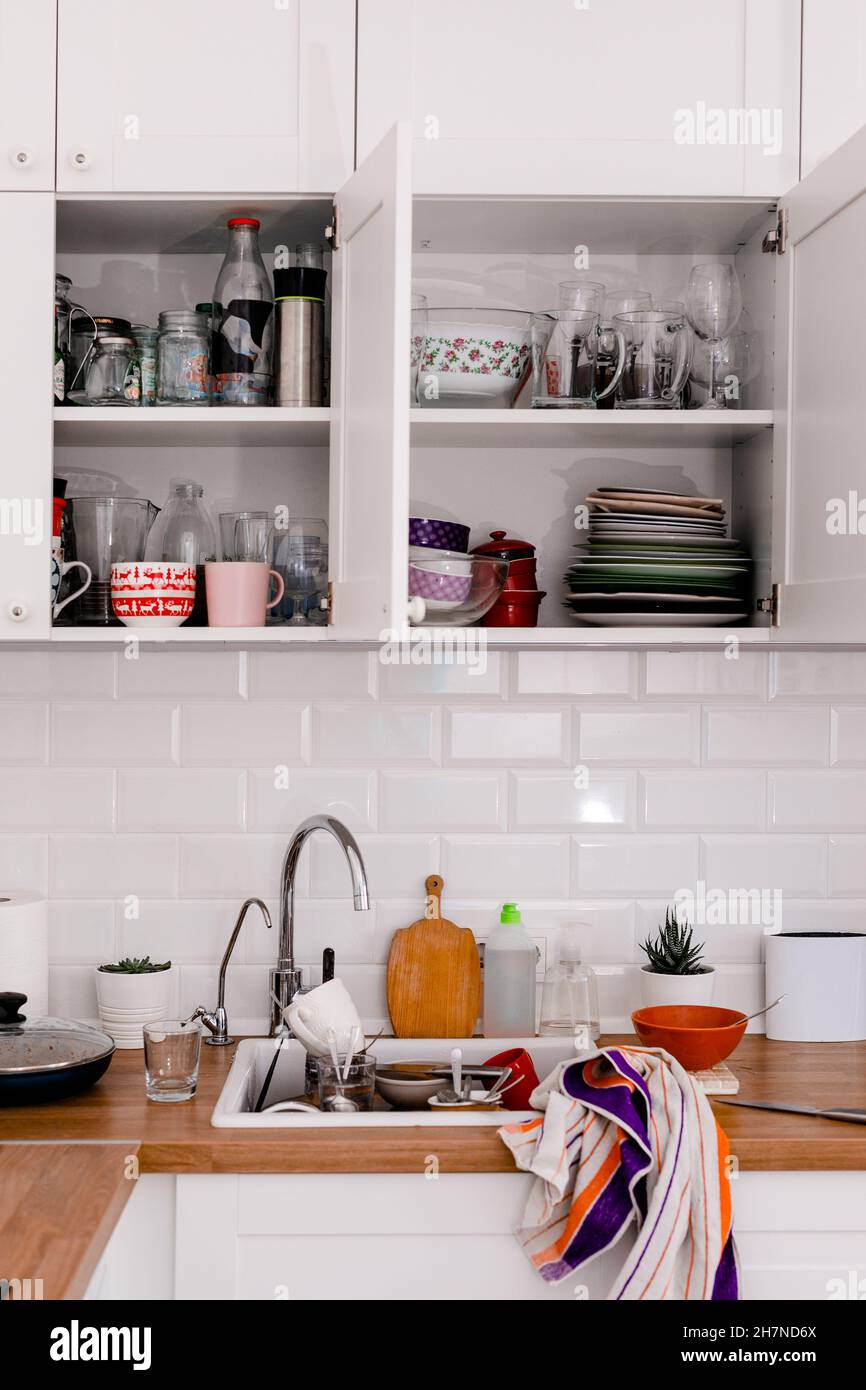 Clutter, dirty dishes by the sink in the white kitchen Stock Photo - Alamy