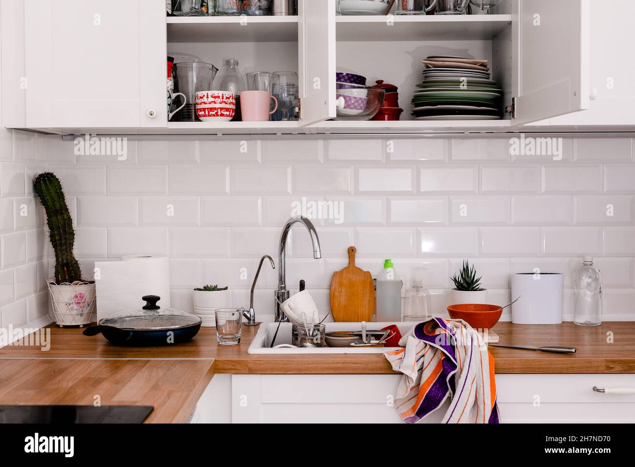 Clutter, dirty dishes by the sink in the white kitchen Stock Photo - Alamy