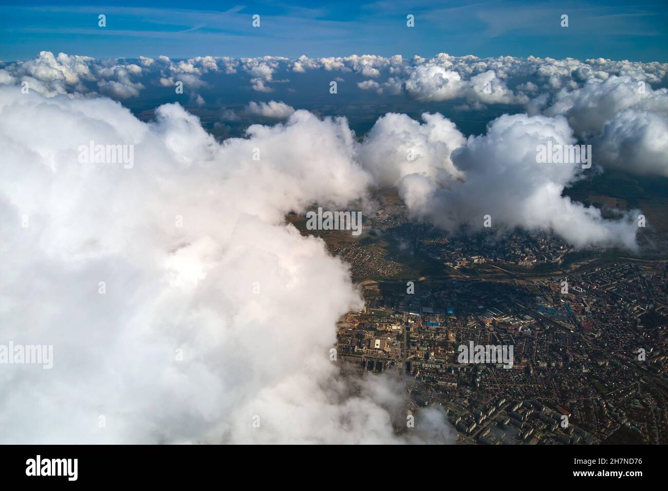 Aerial view from airplane window at high altitude of distant city ...