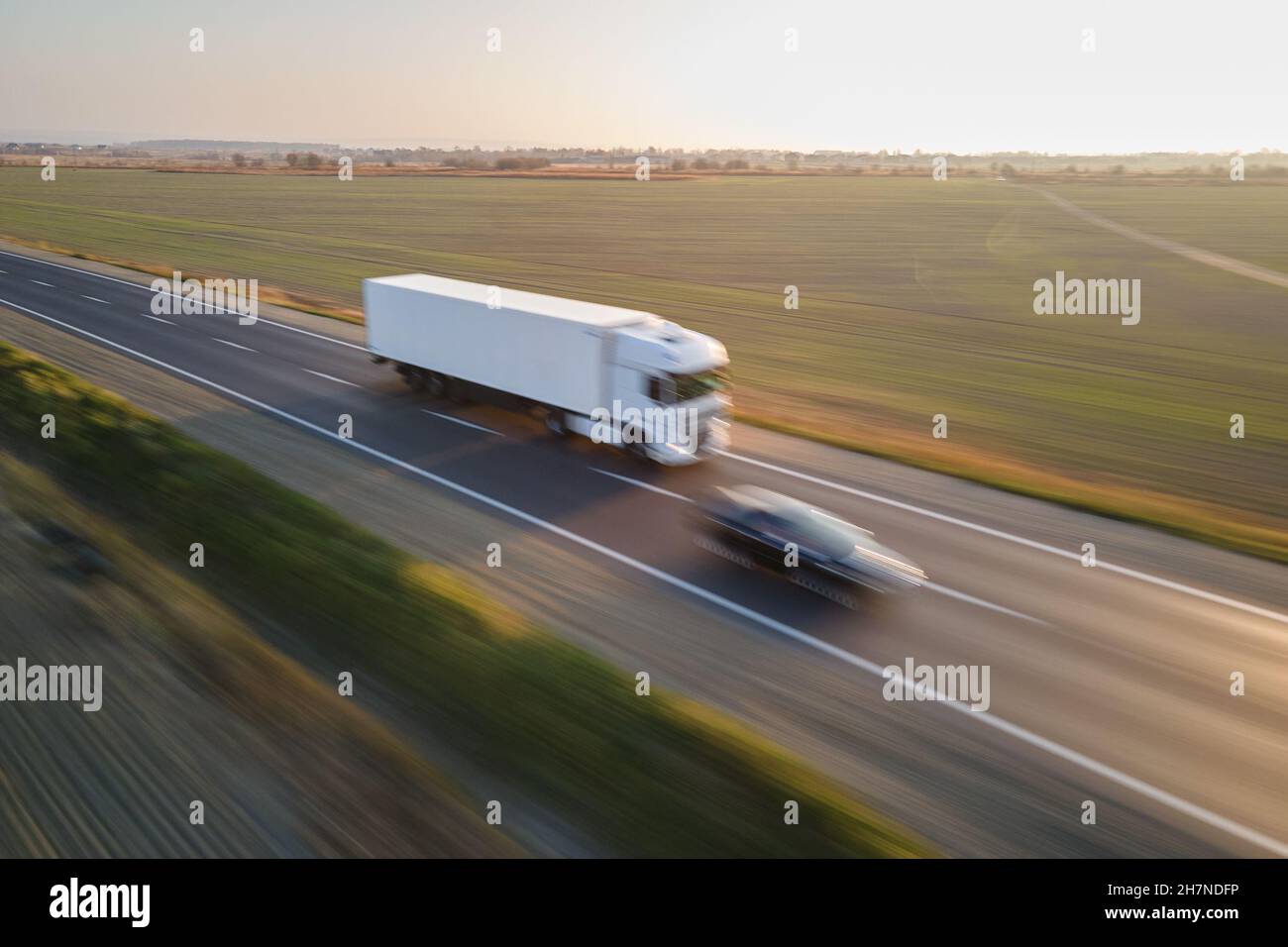 Aerial view of blurred fast moving semi-truck with cargo trailer ...
