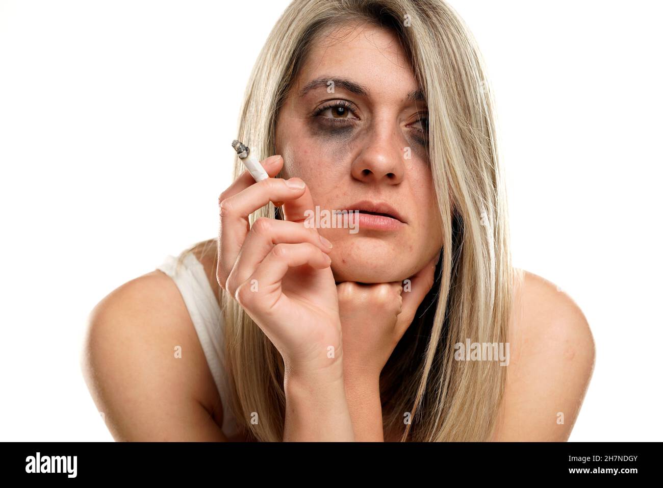 portrait of a young desperate woman with smudged makeup and a cigarette ...