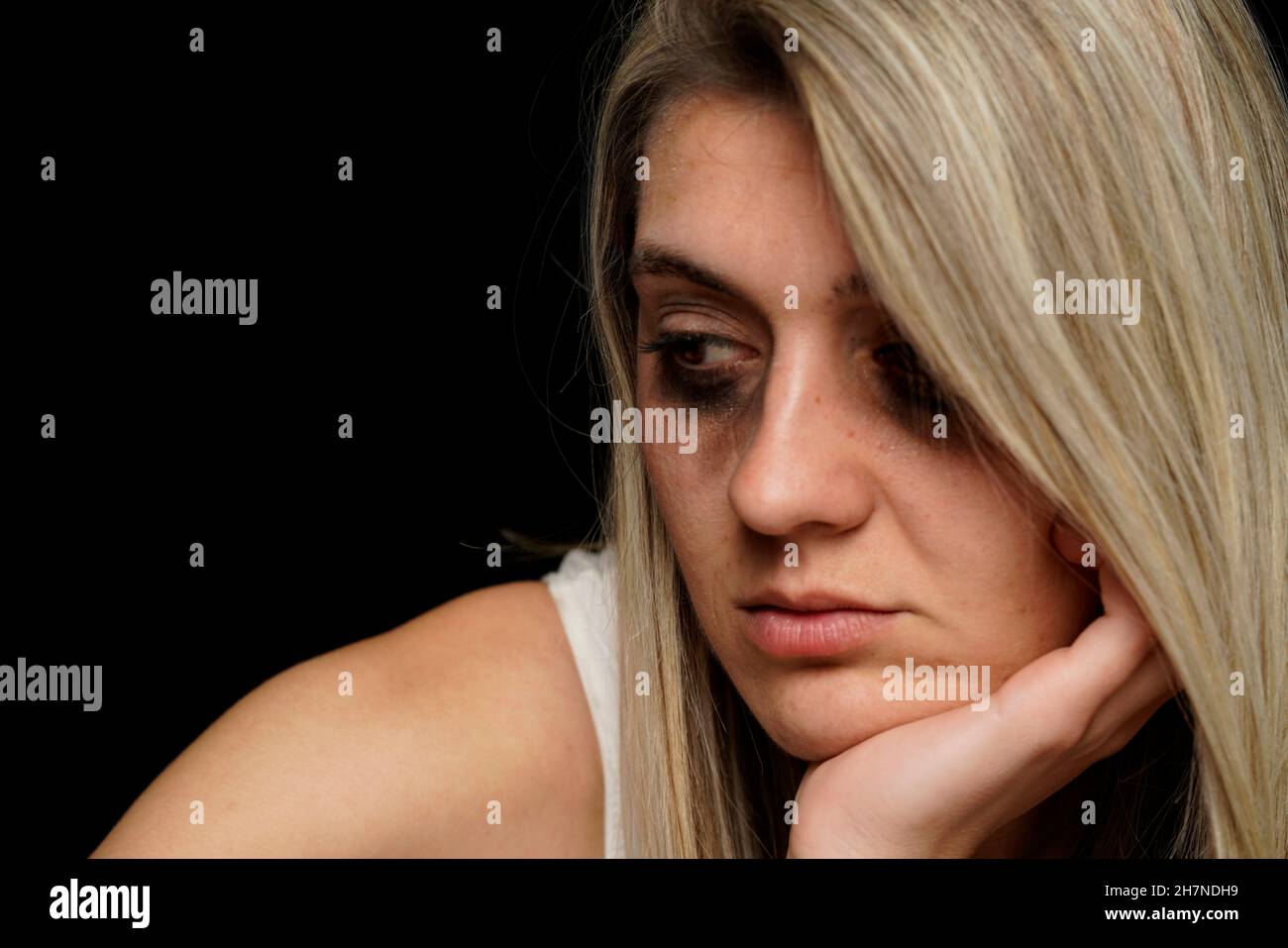 portrait of a beautiful sad woman with smudged makeup on a black ...