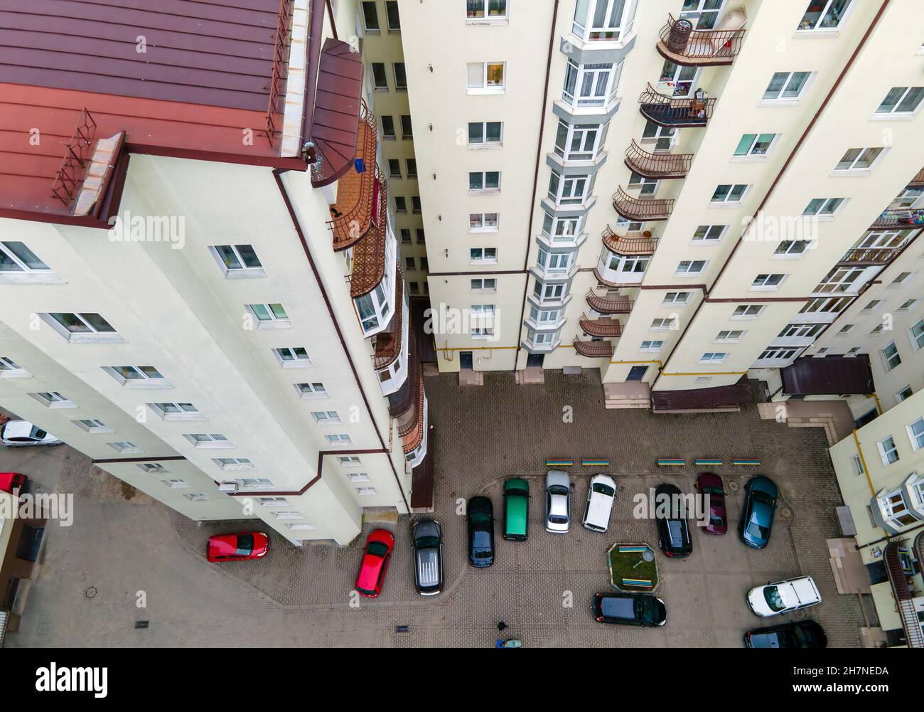 Aerial view of parked cars on parking lot between high apartment ...