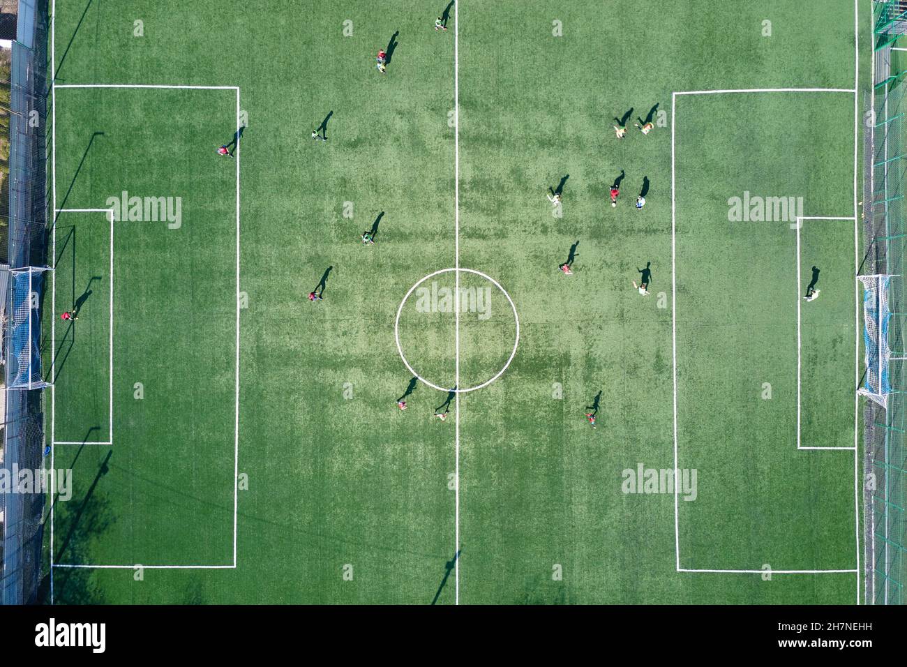 Aerial view of soccer players playing football on green sports stadium ...