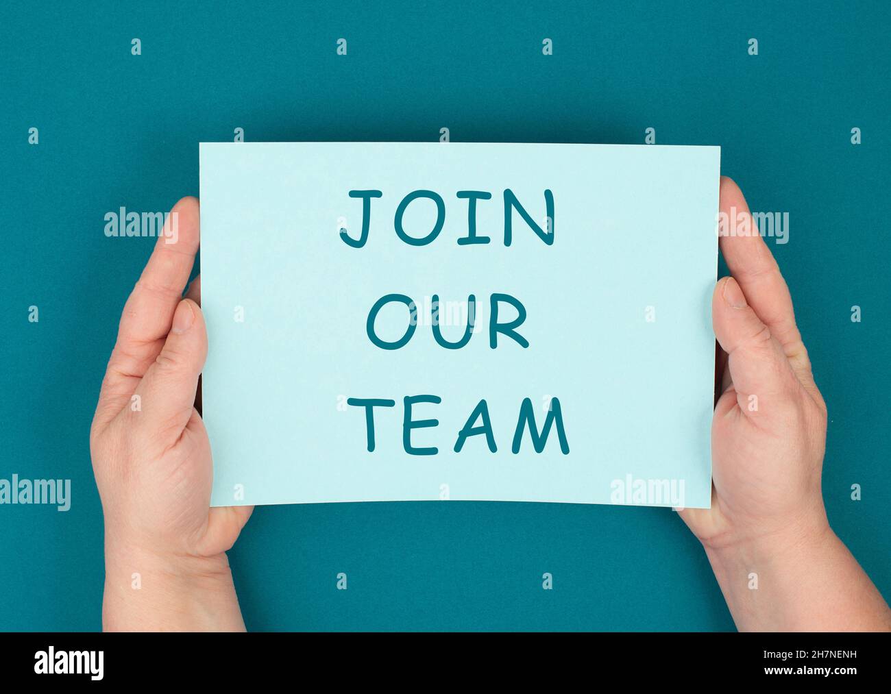 The words join our team are standing on a paper, yellow colored ...