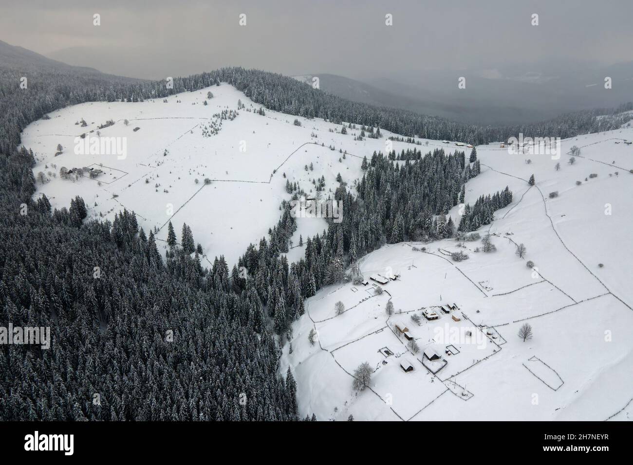 Aerial winter landscape with small rural houses between snow covered ...