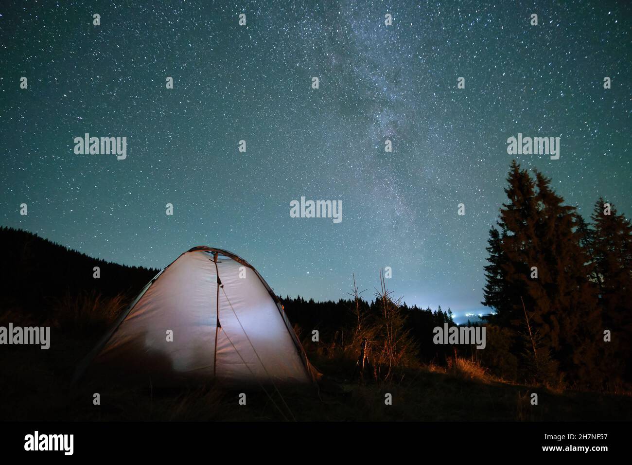Bright illuminated tourist tent glowing on camping site in dark ...