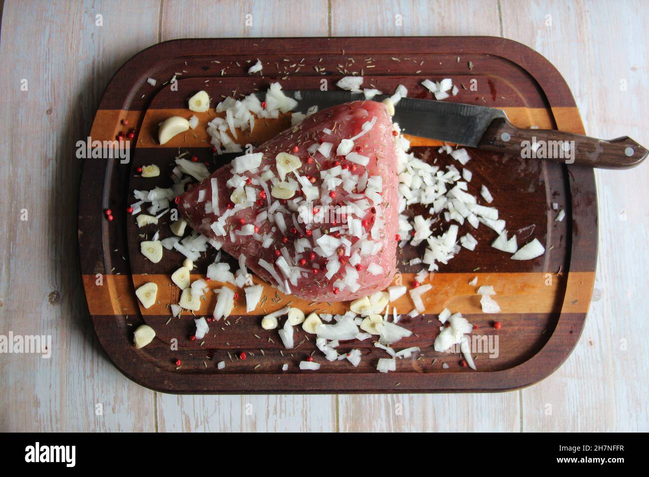 Close-up of pork filet mignon seasoned with spices and onion on a ...