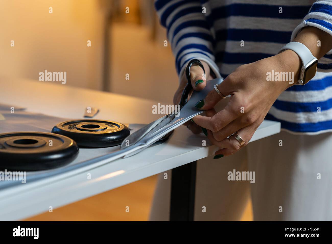 Clothing designer cut fabric using scissors and weights. Sewer working ...