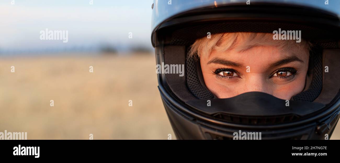 portrait of a pretty blonde woman biker looking at the camera with her ...