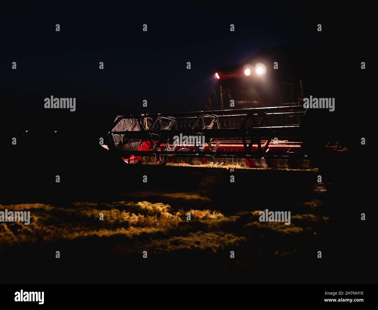 Combine harvester working in a rice field at night Stock Photo - Alamy