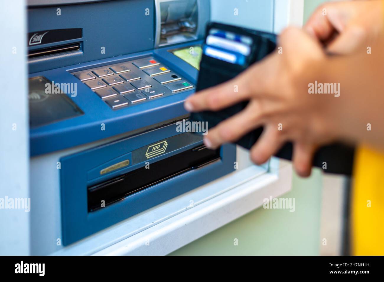 withdraw cash from an ATM on a city street Stock Photo - Alamy