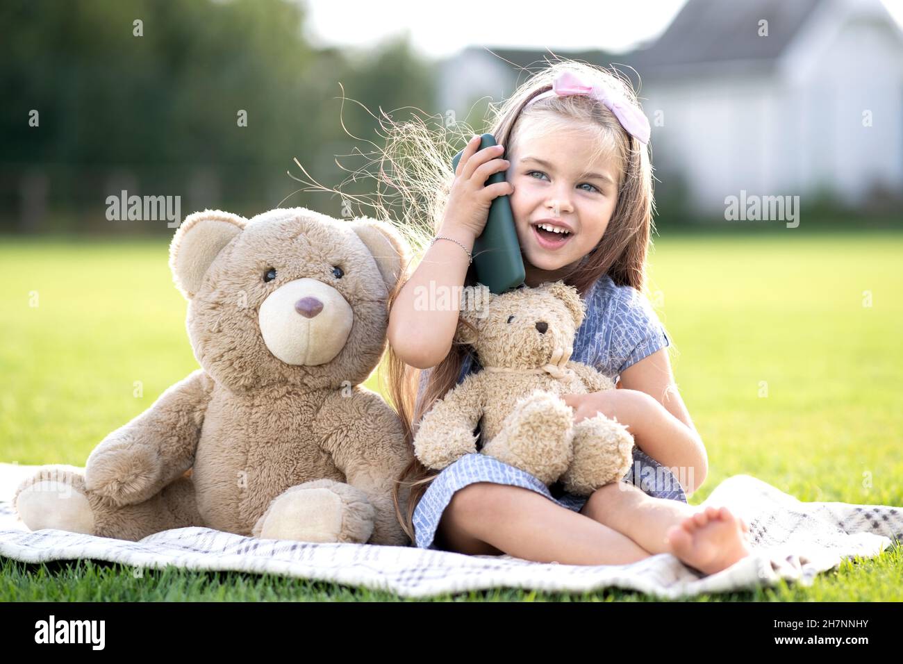 Pretty little child girl talking on mobile phone smiling happily ...