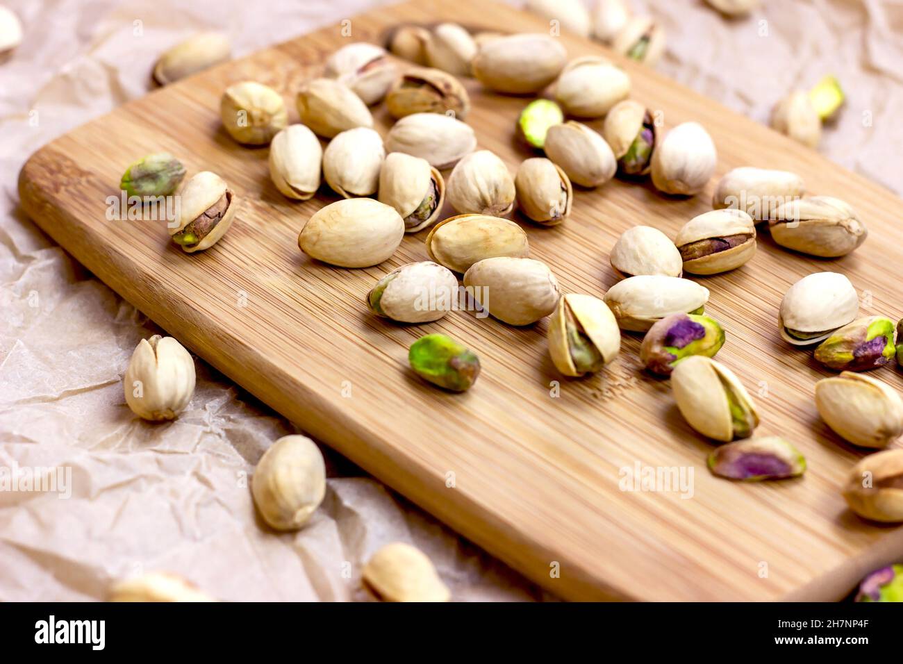 Roasted salted pistachio nuts in nutshell on wooden board background Stock Photo - Alamy