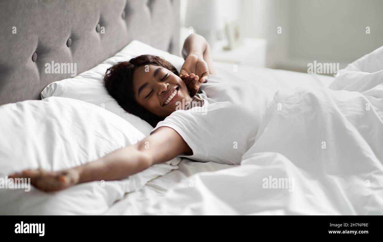 Young black woman enjoying happy morning in bed Stock Photo - Alamy