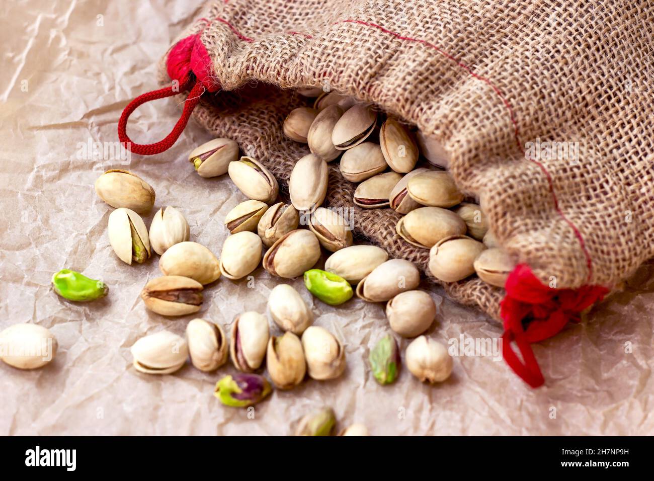 Roasted salted pistachio nuts in nutshell in the textile bag on light background Stock Photo - Alamy