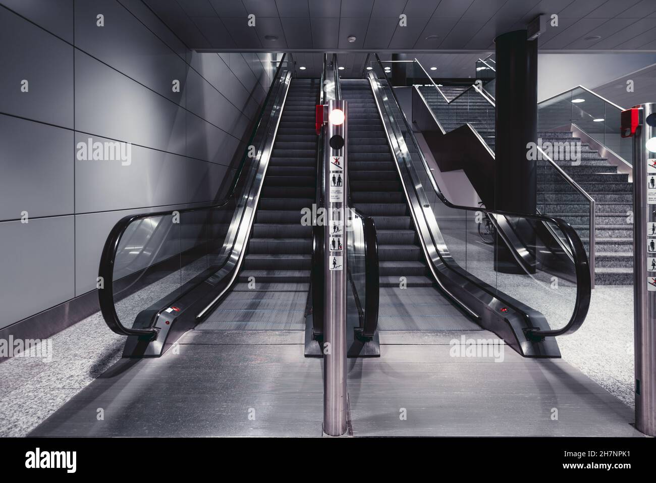 A front view of a contemporary bi-directional escalator made of glass ...