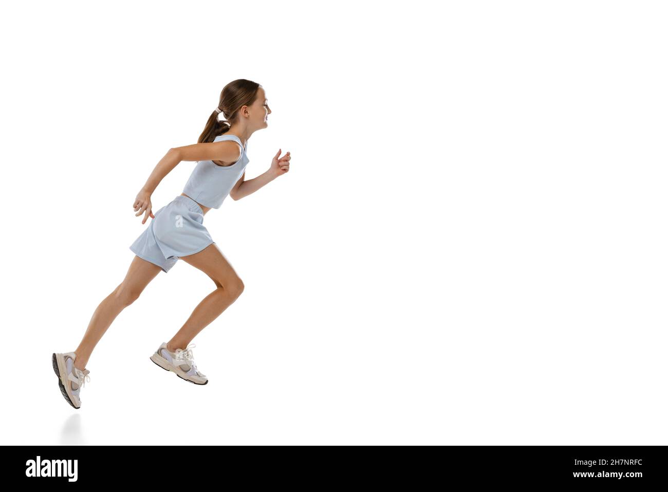 Full-length side view portrait of girl, teenager, professional runner ...
