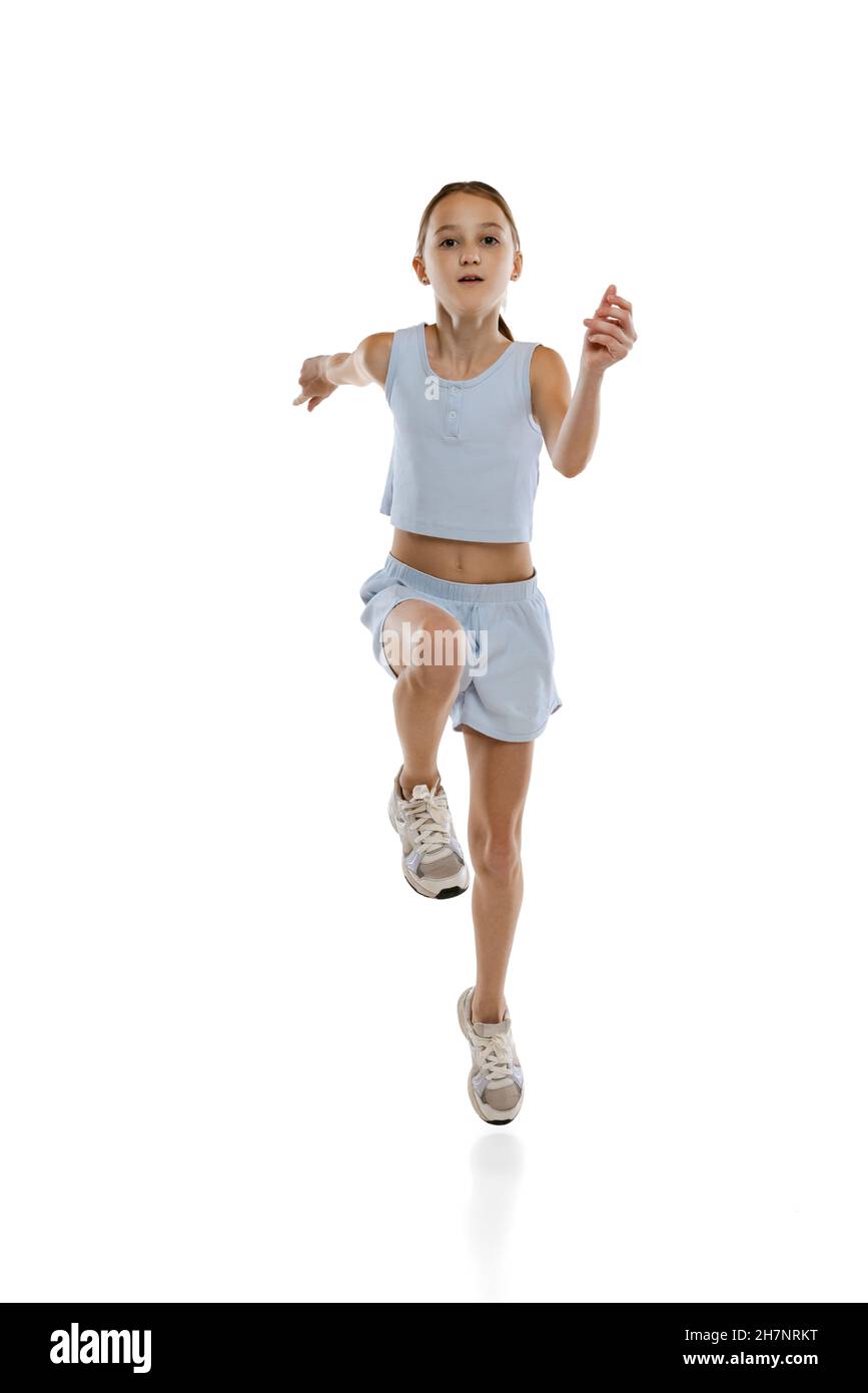Front view portrait of teen girl training, running isolated over white ...
