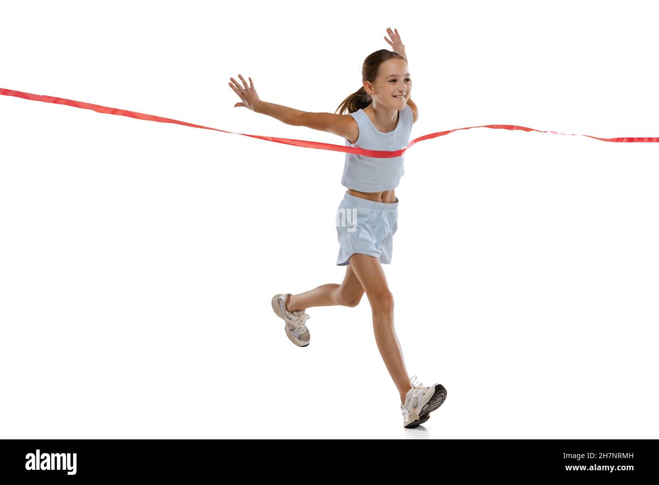 Full-length portrait of teen girl crossing red winning marathon ribbon ...