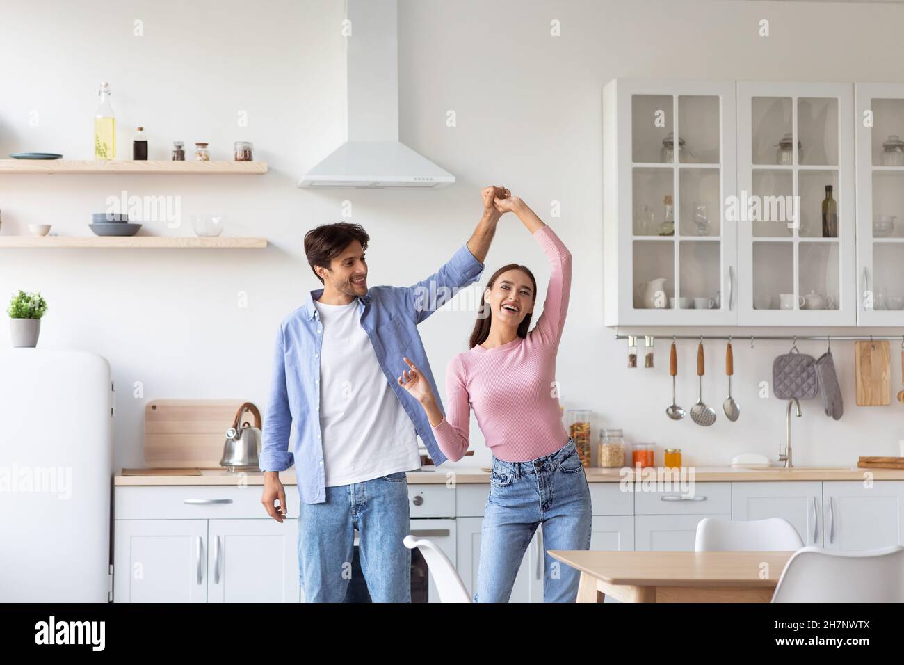 Happy young european couple have fun in modern kitchen interior. Loving ...