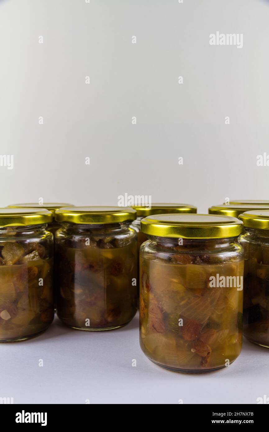 Chutney after courgette grew into marrow. Several jars white background ...