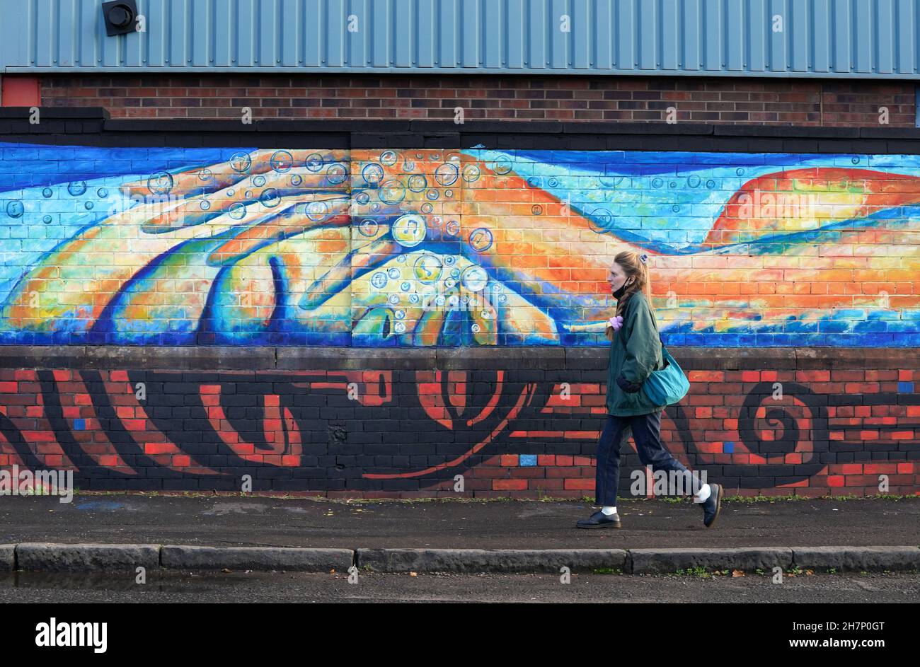 A person walks passed a mural by Mexican artist and activist, Gustavo ...