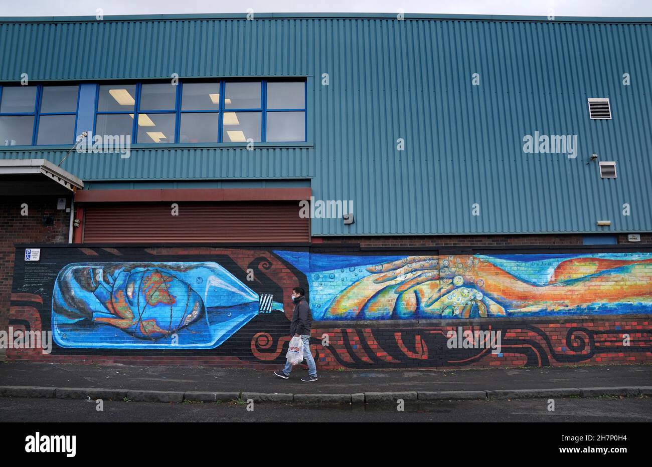 A person walks passed a mural by Mexican artist and activist, Gustavo ...