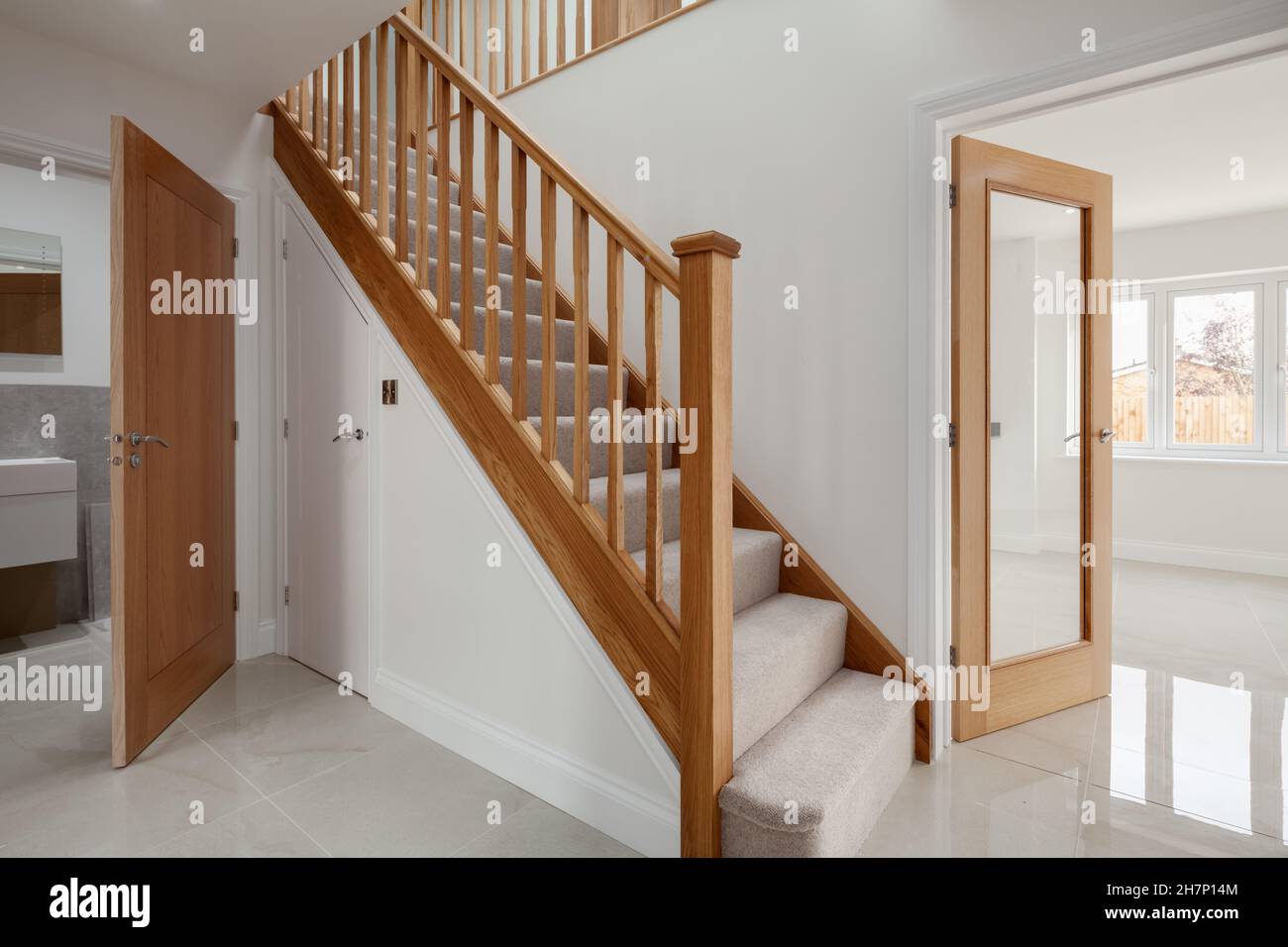 New home entrance hall, empty of furniture with stairs leading to first ...