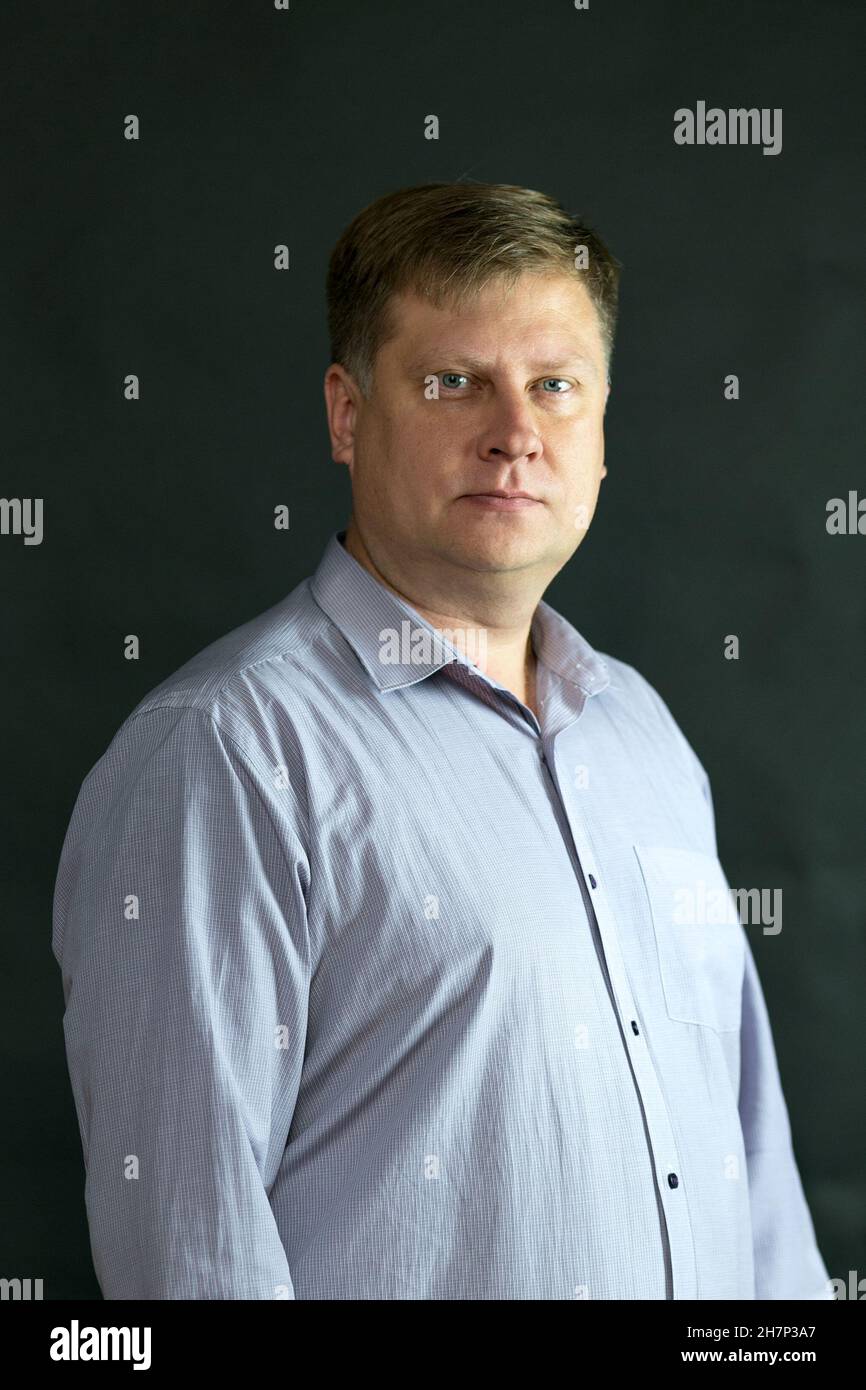 Adult tall blonde 40 years old in strict shirt on a black background ...