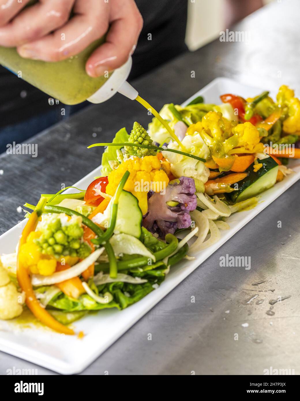 Dressing a Salad - the final step before chefs salad leaves the kitche ...