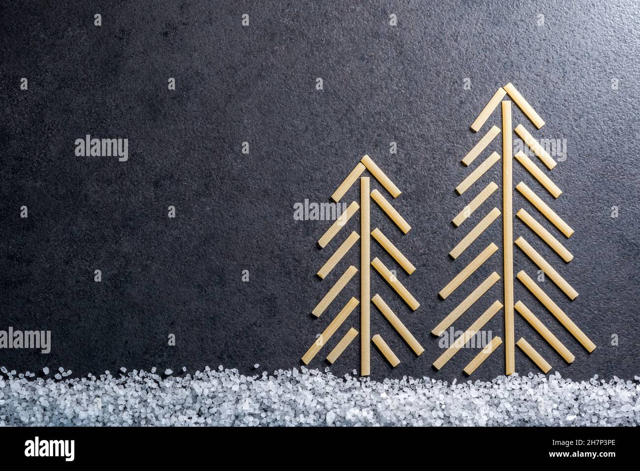 Christmas tree made with italian noodles with salt on a dark background ...
