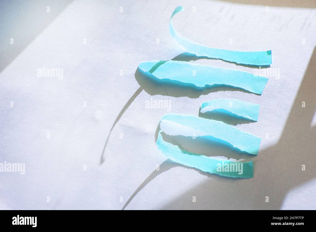 Abstract blue torn paper strips on a white background with a shadow ...
