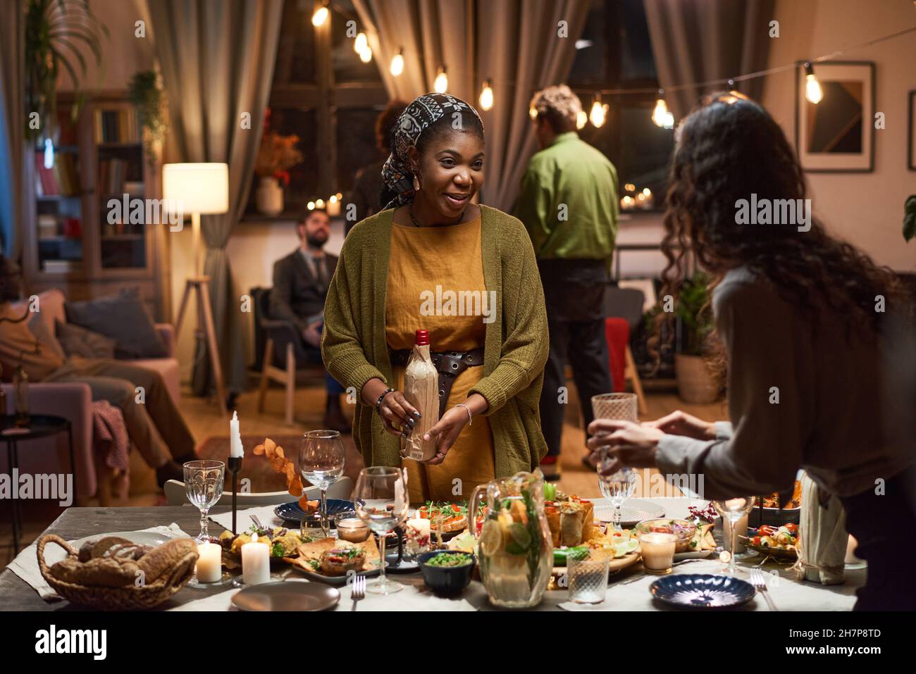 Two women talking to each other while setting the dining table and ...