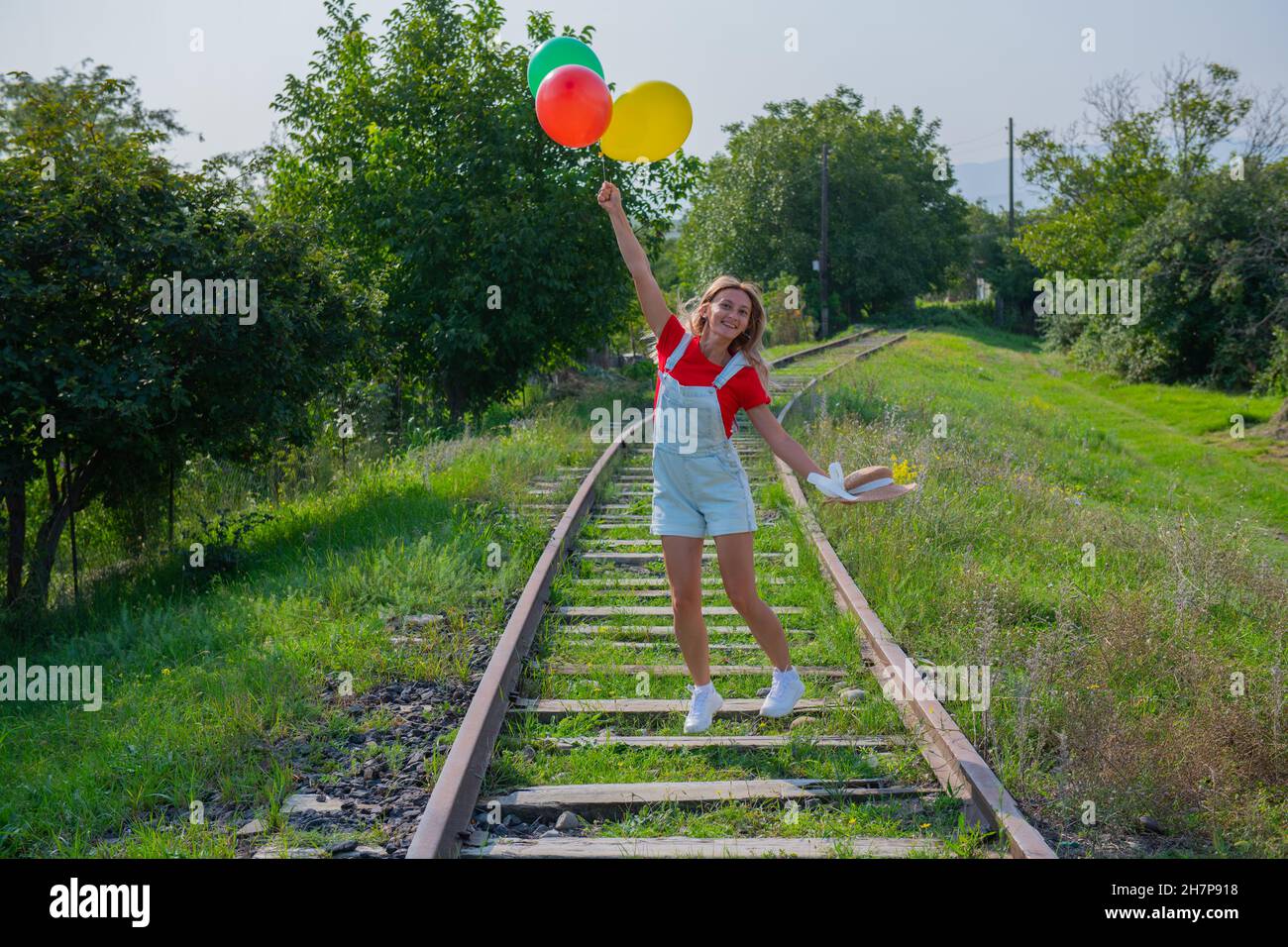 one girl with balls on the railroad goes Stock Photo - Alamy