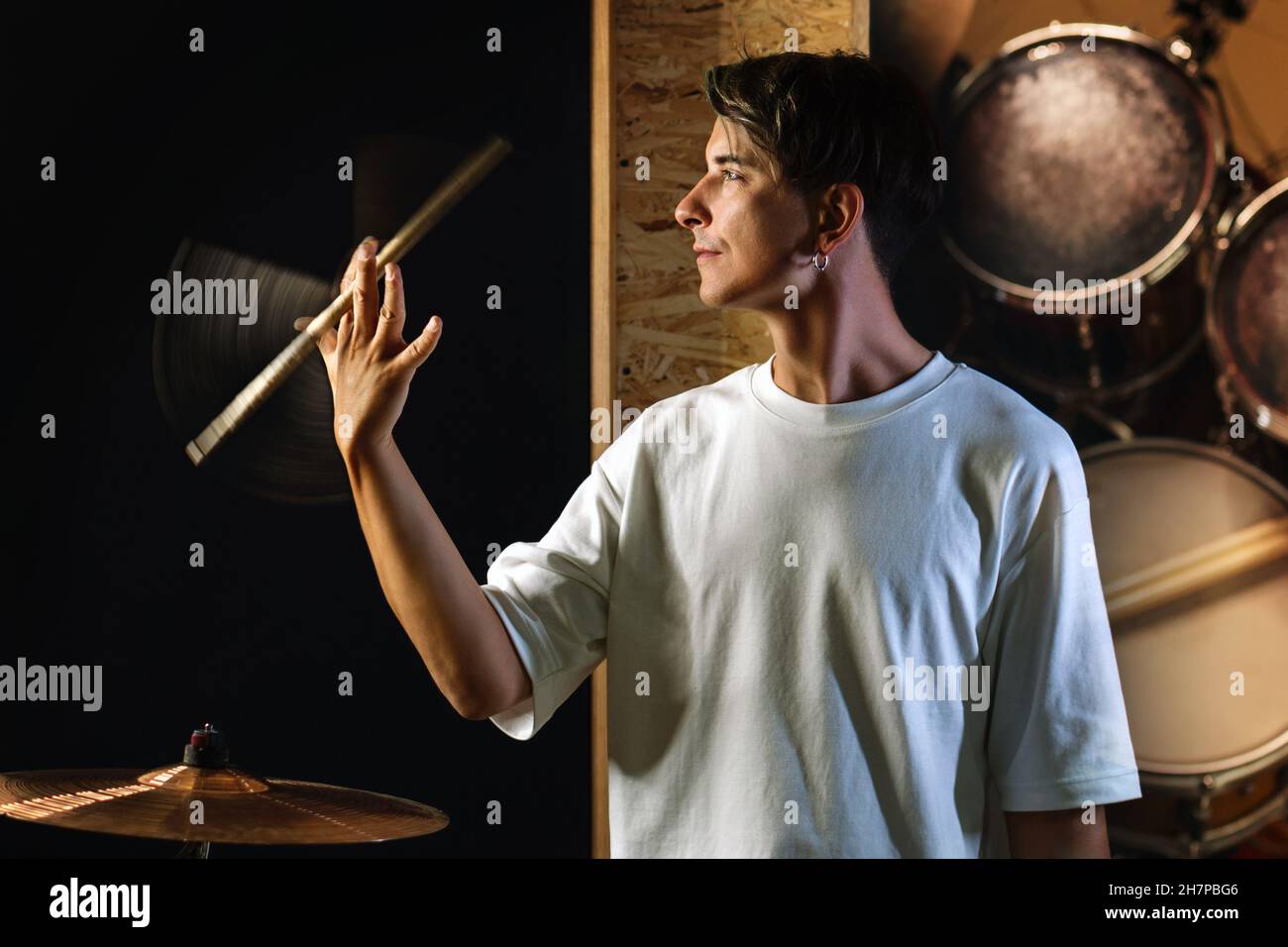 Side view lifestyle portrait young handsome drummer. Guy posing with ...