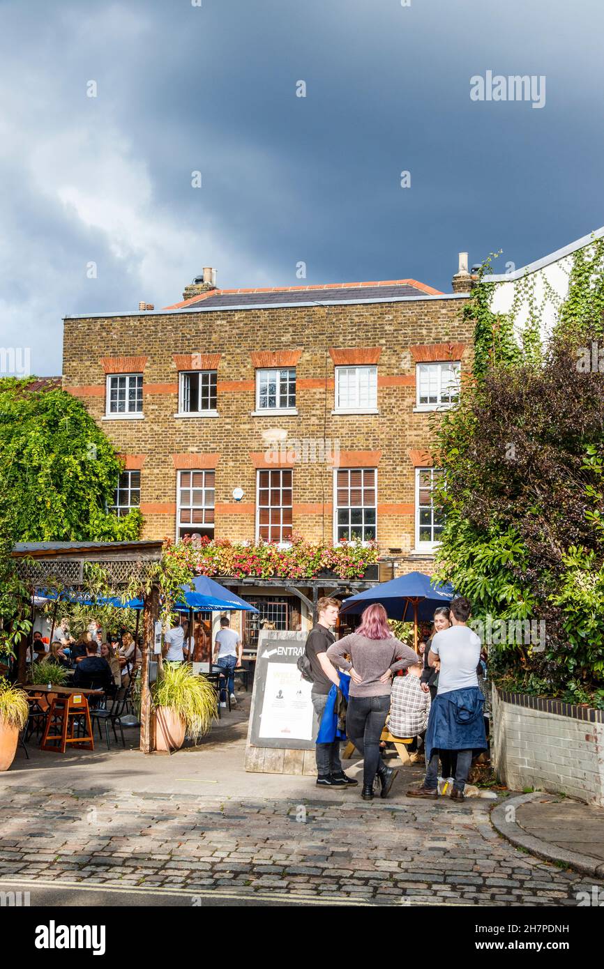 Drinkers in the beer garden of The Flask, a traditional pub in Highgate ...