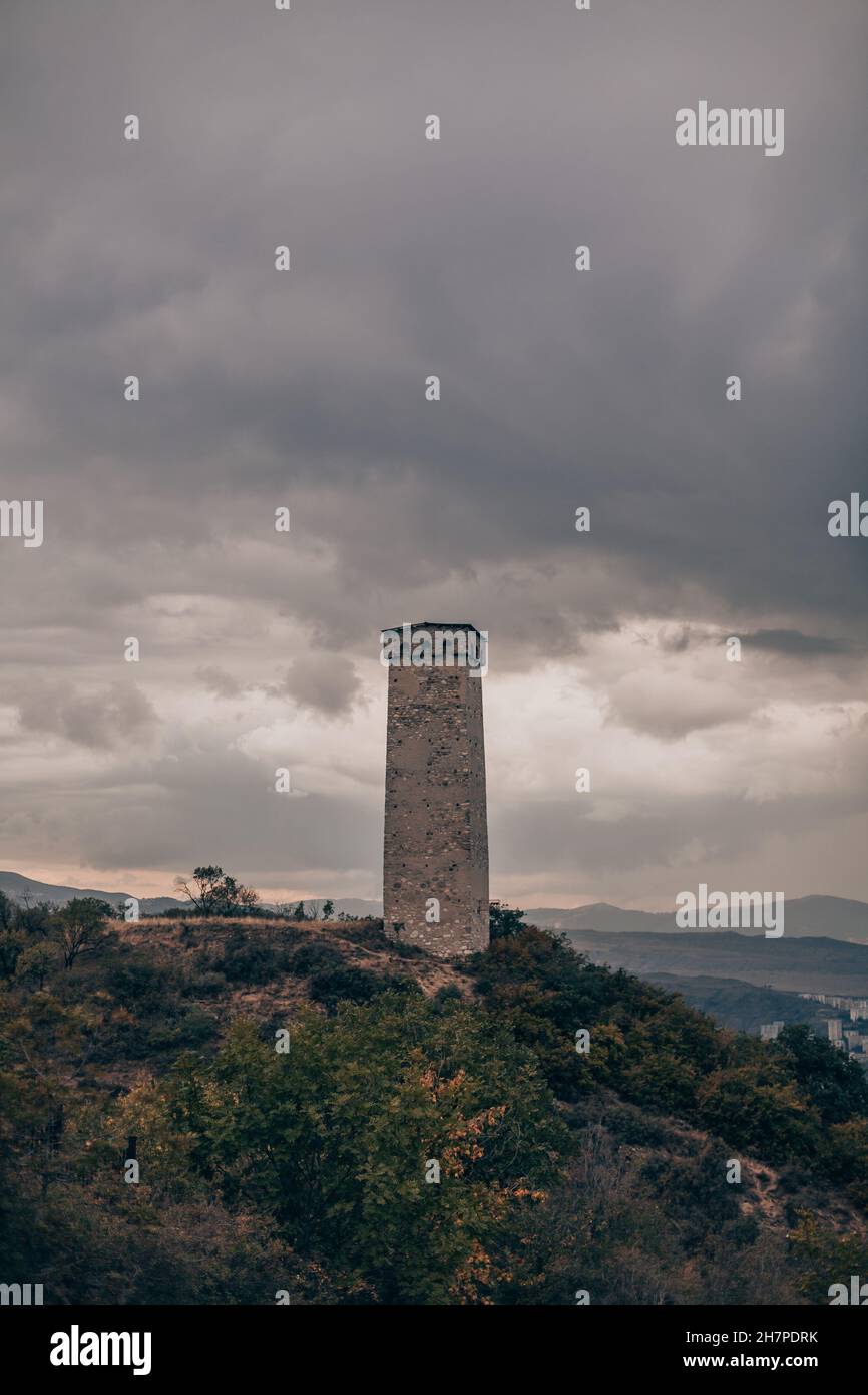 Large ancient stone tower stands on a hill in the forest. Mountain view ...