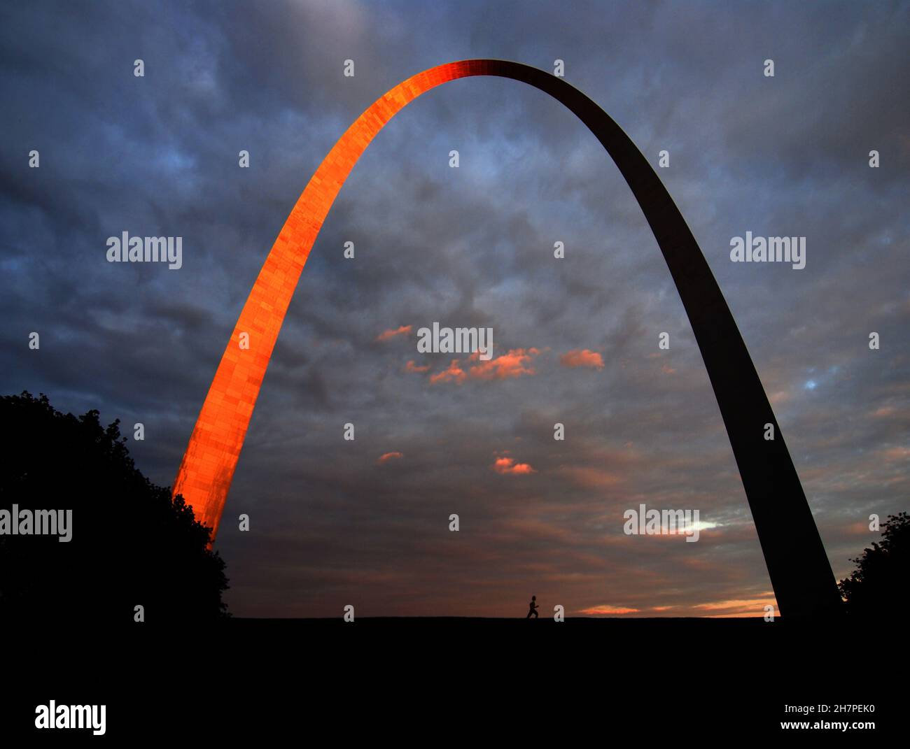 St Louis Arch landmark metal gateway sunset glowing orange withperson ...