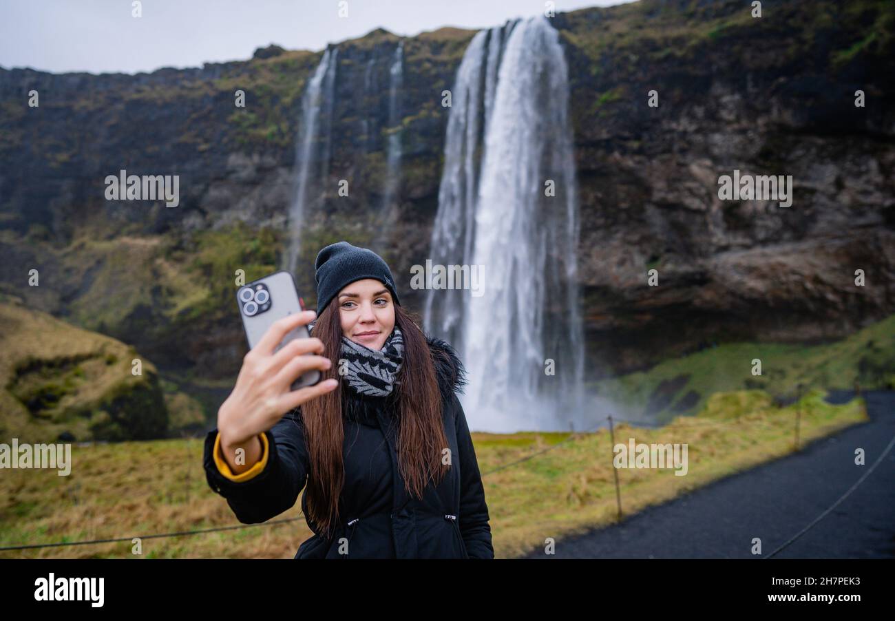 Woman traveler selfie by Seljalandsfoss waterfall on Ring Road in ...