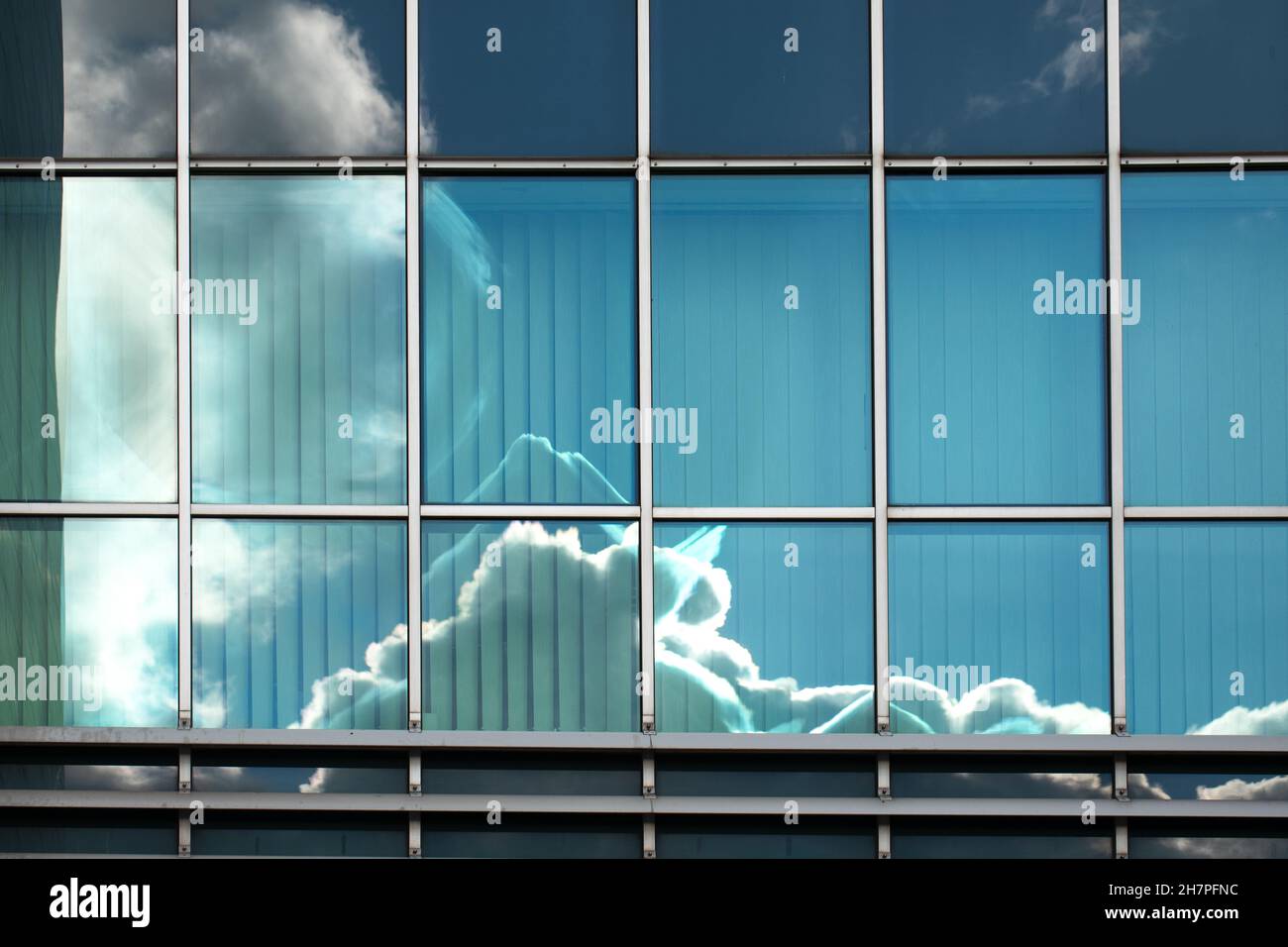 Reflection of clouds and blue sky in the glass structure of a ...