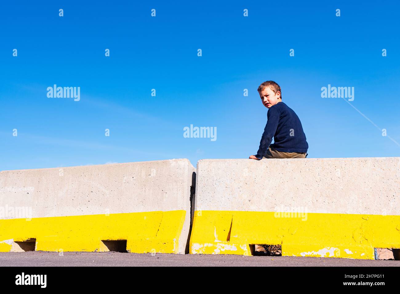 A child play on some construction barriers running into danger ...