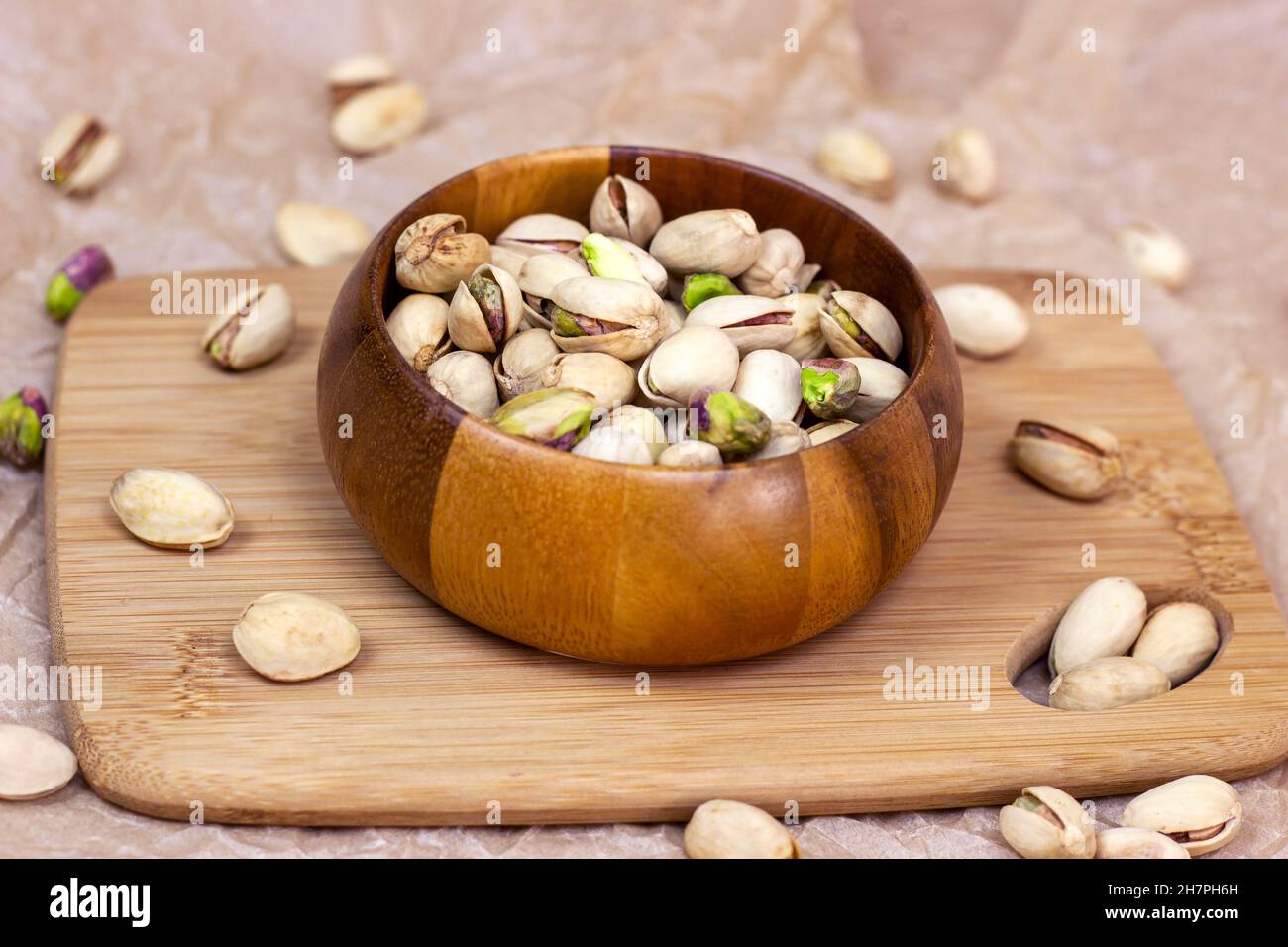 Roasted salted pistachio nuts in nutshell in wooden bowl on textured background Stock Photo - Alamy