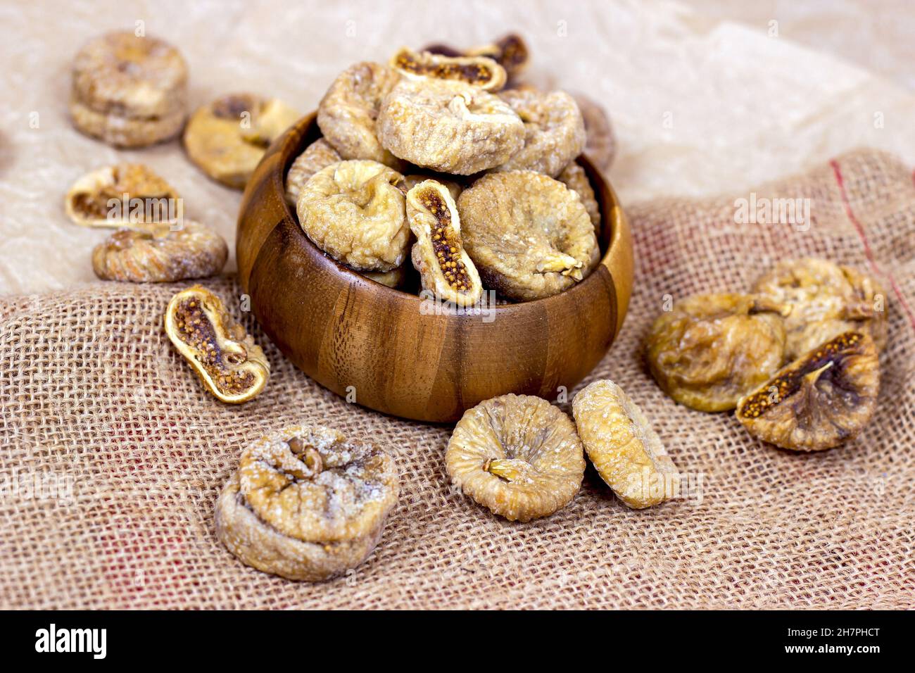 Sweet dried italian figs in the wooden bowl on the brown cutting board ...