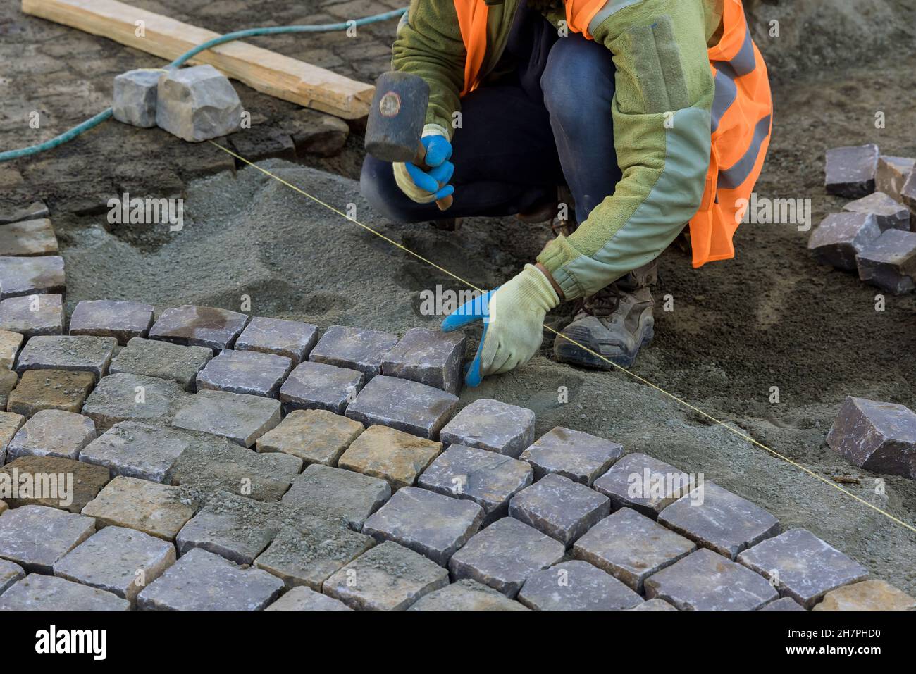 Installation of paving stone granite cubes on a sandy base Stock Photo ...