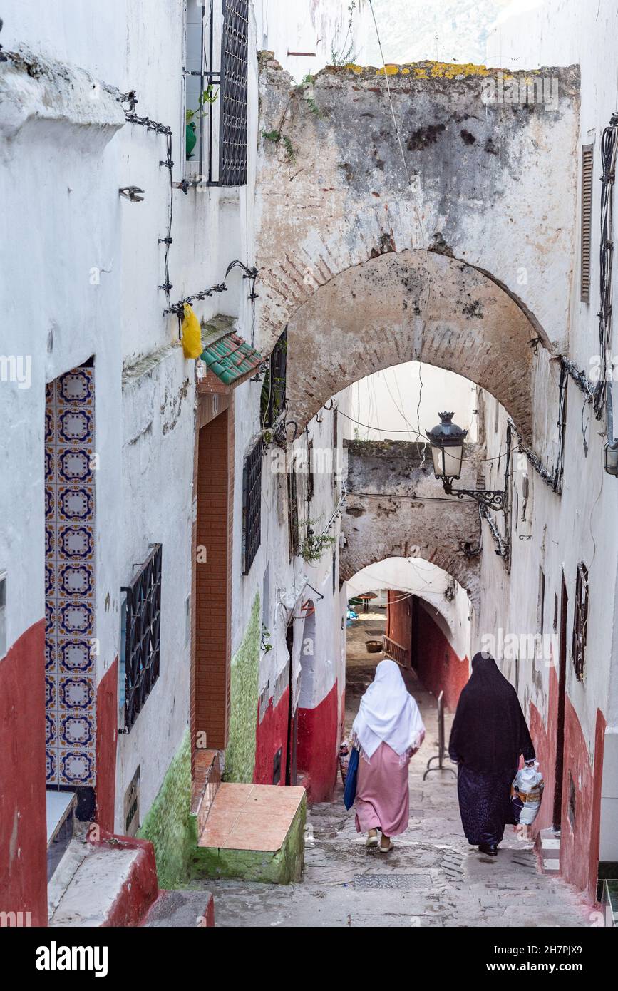 In the medina of Tetouan in Morocco. two women wearing a veil go down ...