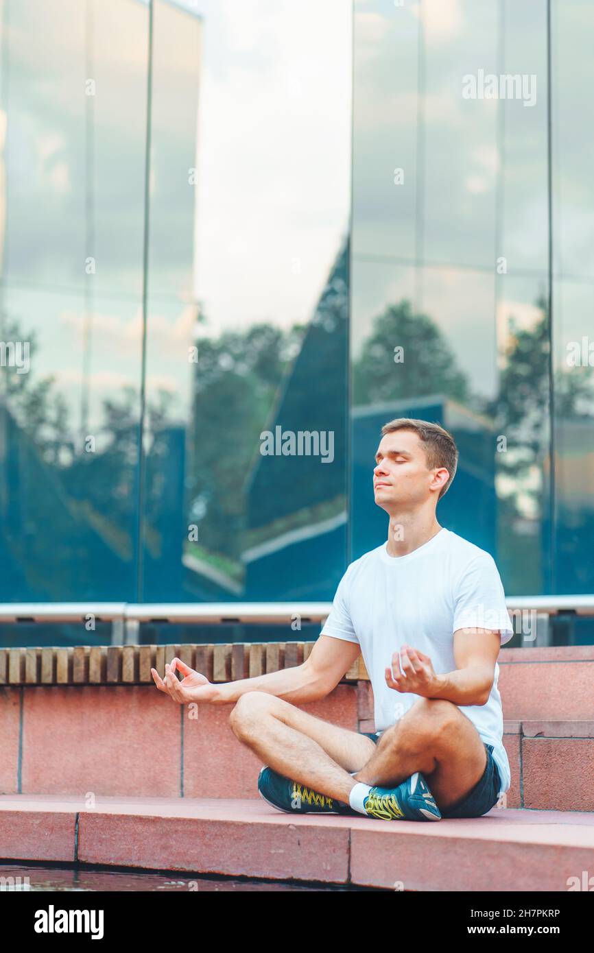 Attractive man athlete wearing sportswear meditate sitting in lotus ...