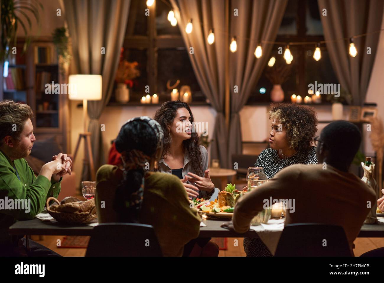 Group of friends talking to each other at dining table during a meeting ...