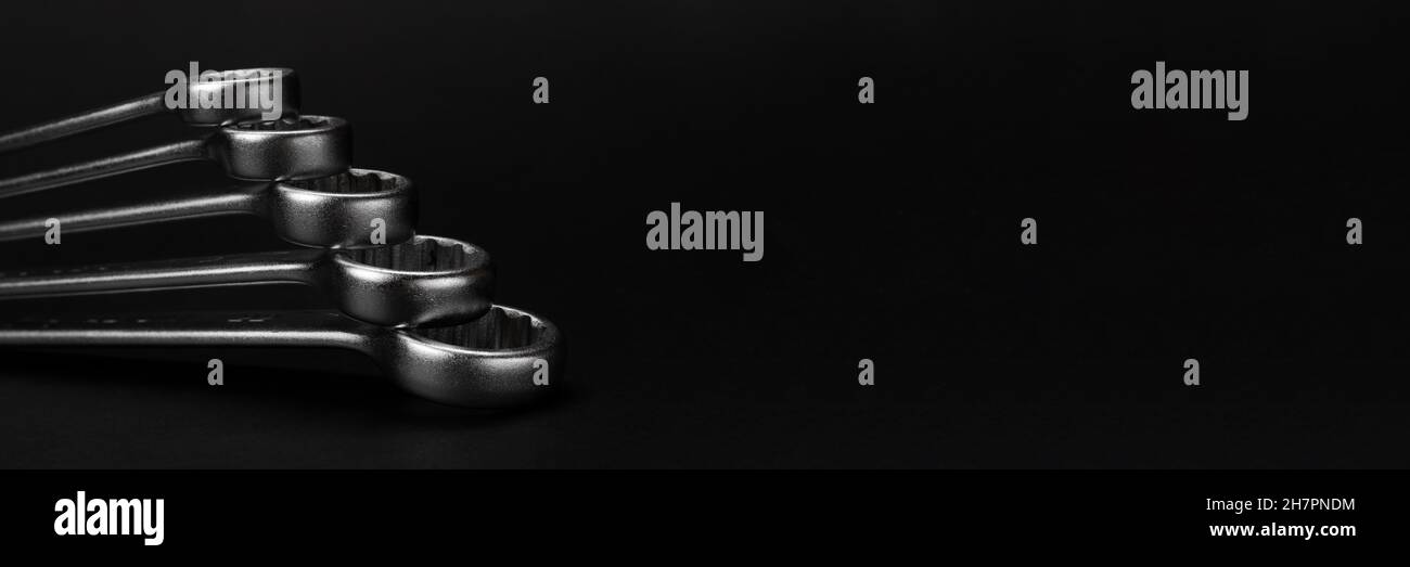 Steel wrenches on black background. Wide panoramic banner with copy ...
